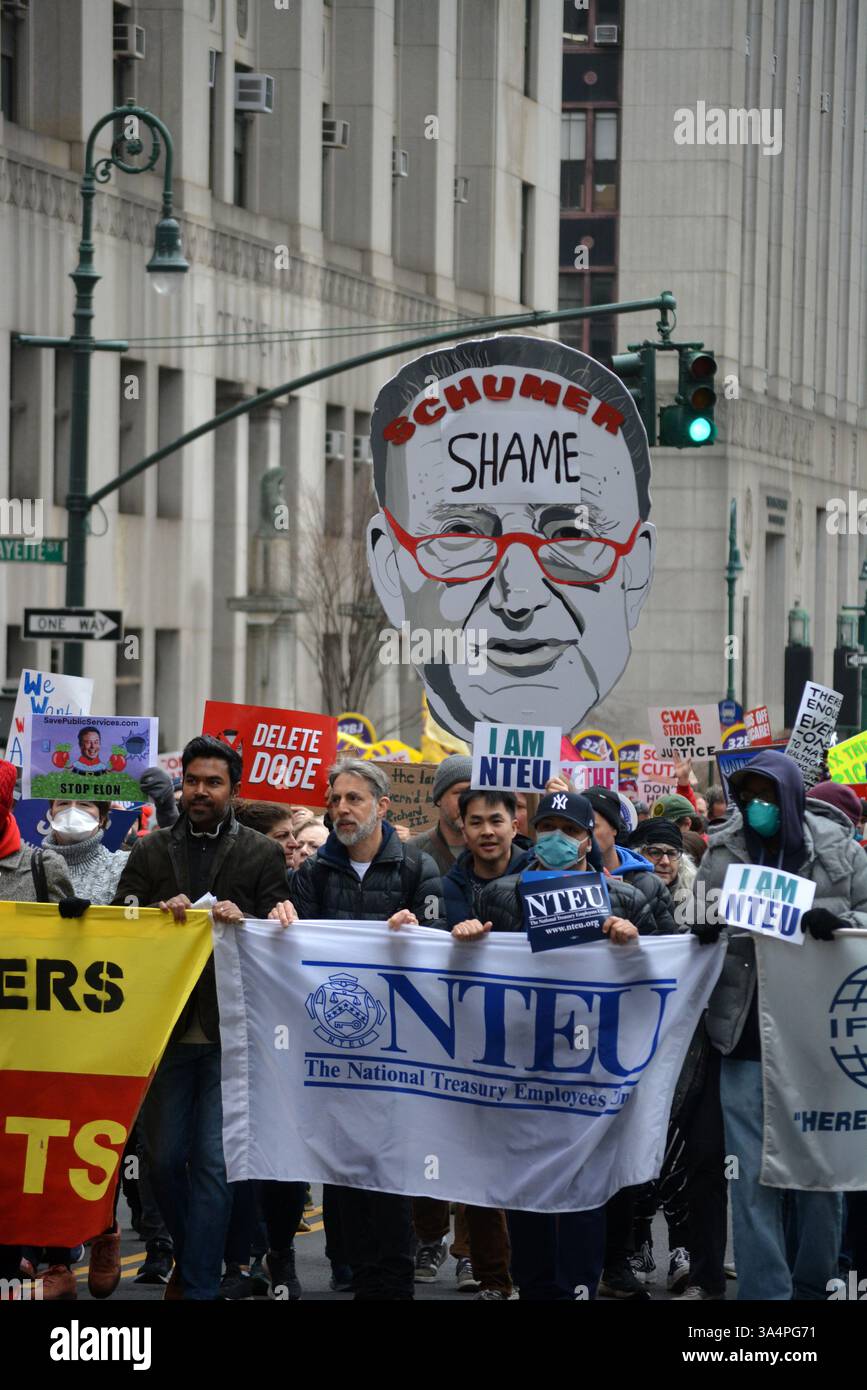 People marching with signs at a Stop the Cuts rally against DOGE in ...