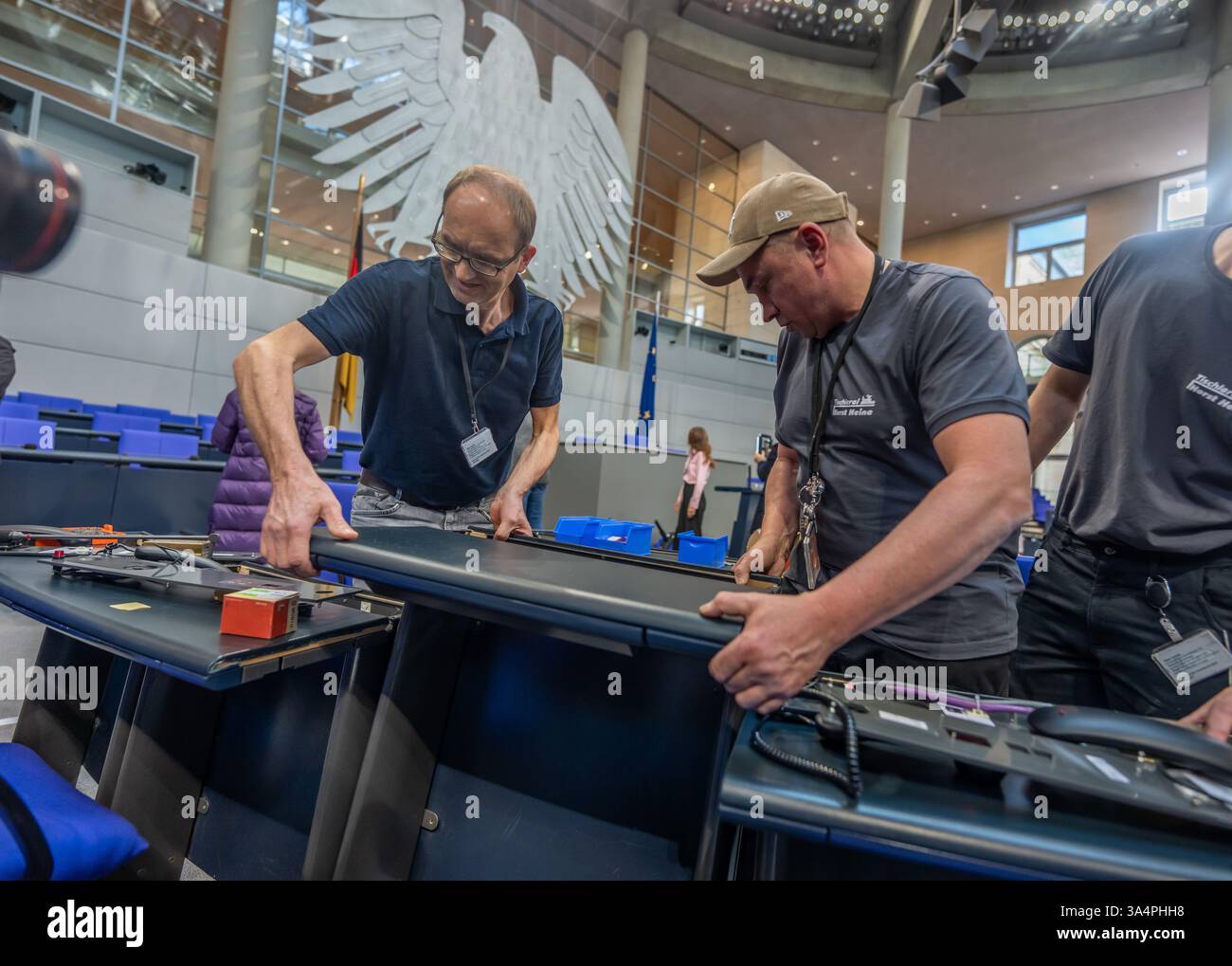 19 March 2025, Berlin: Craftsmen rebuild the plenary chamber in the ...