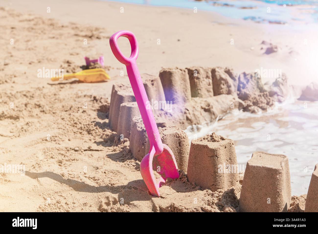Simple sandcastle on fine sandy beach under the expansive blue sky ...