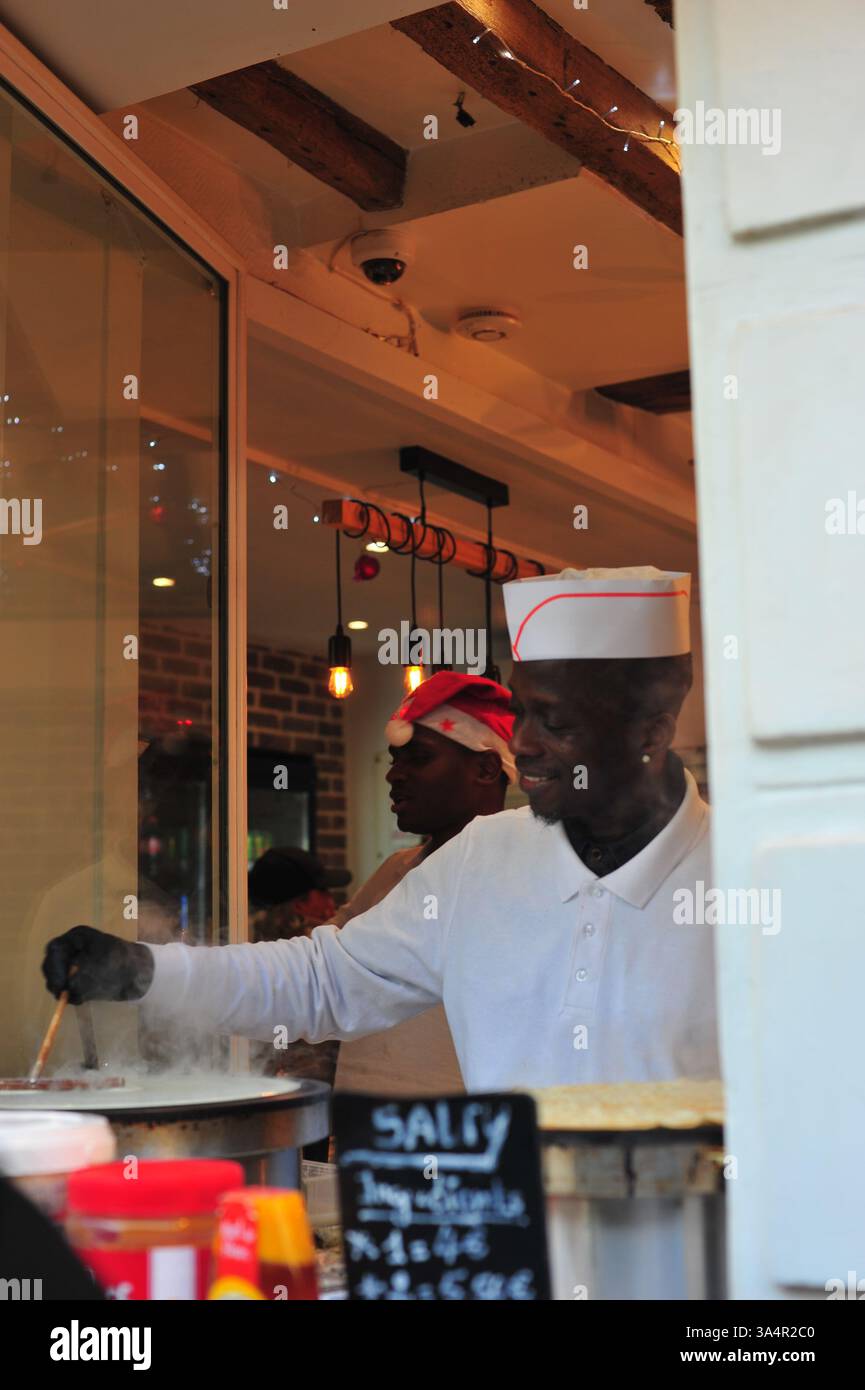 parisian black man cooking crepe in a tradicional restaurant in Paris ...