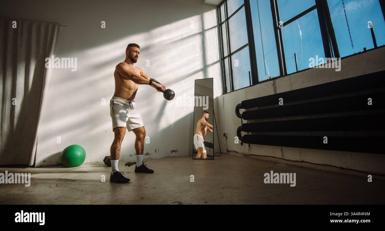 Engaging in Strong Man Training with a Kettlebell in a Contemporary Gym ...