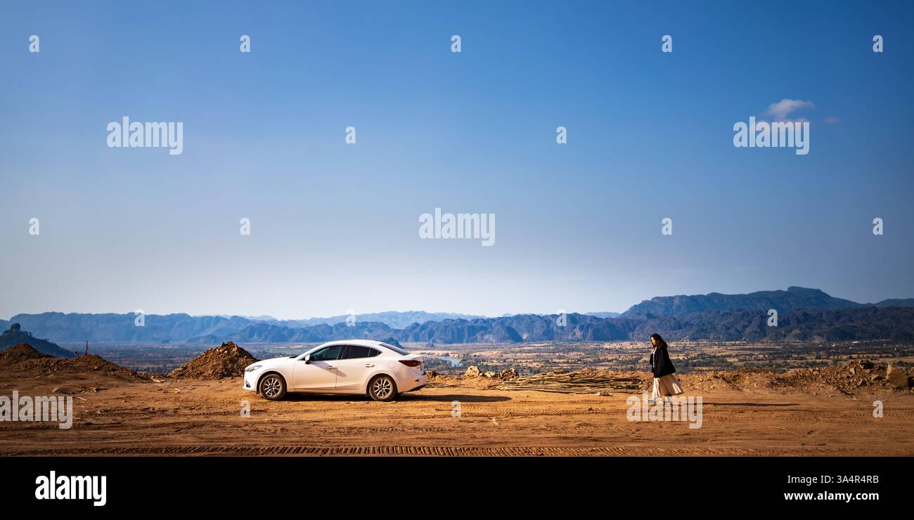 A solitary figure and a car in a vast landscape. This image captures ...
