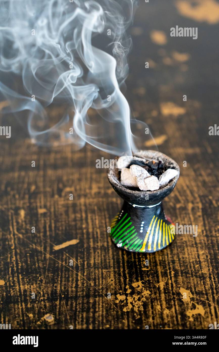 Ethiopia, incence is burning on charcoal during the coffee ceremony ...