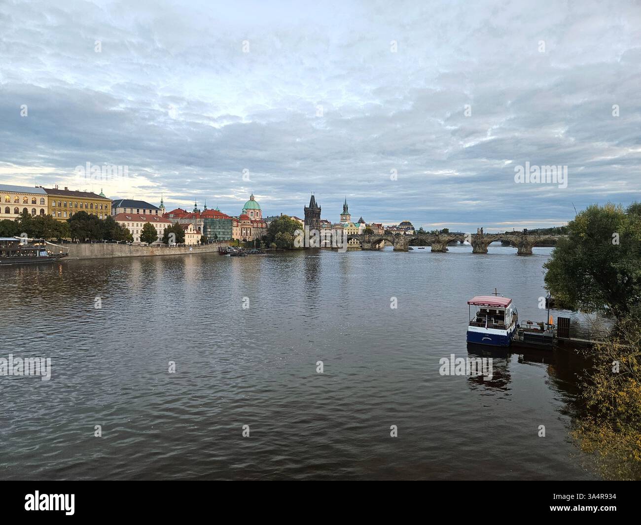 A distant view of Charles Bridge in Prague, spanning the Vltava River, with the surrounding ...