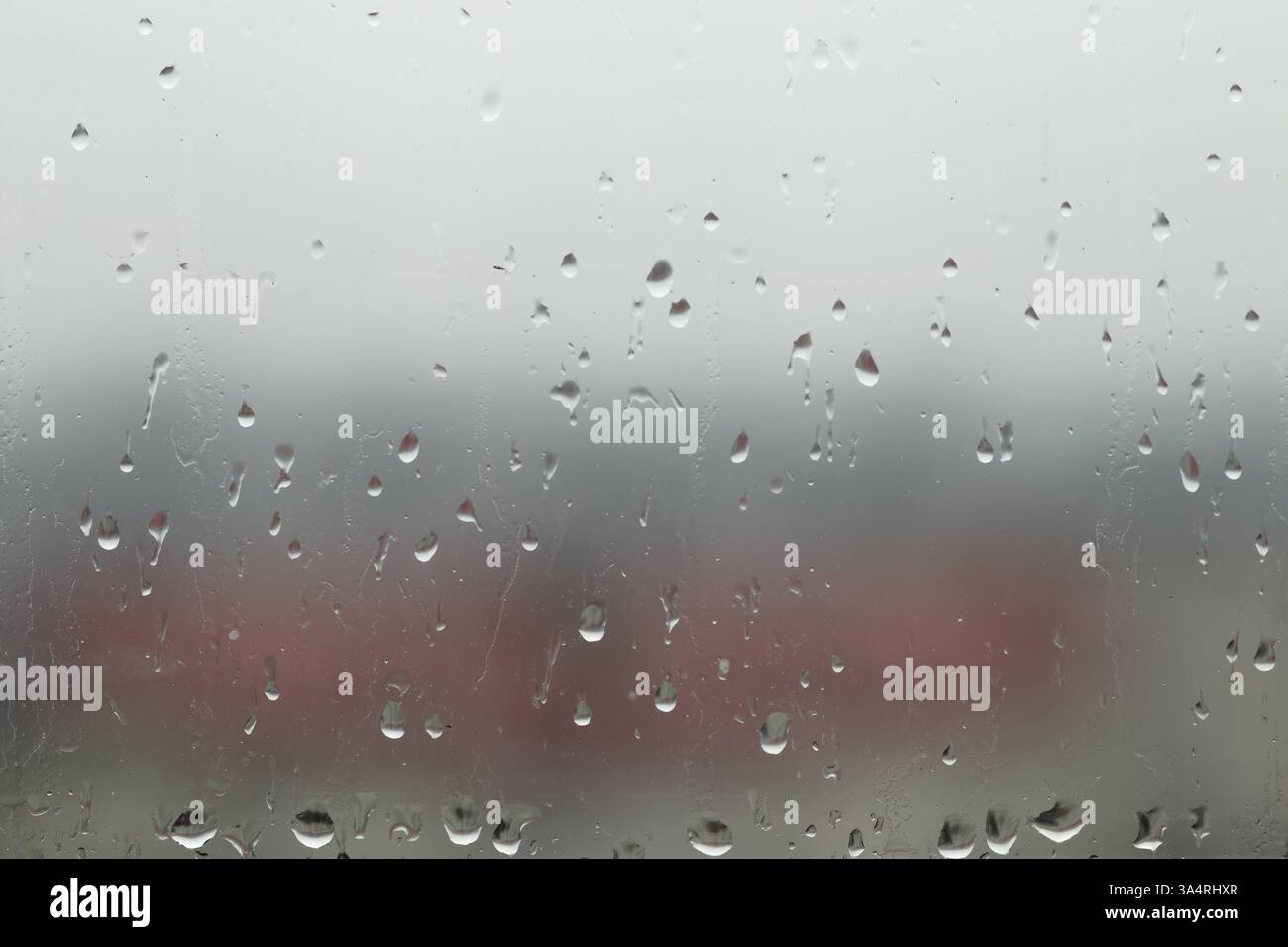 A close-up image of raindrops on a window, with the water droplets ...