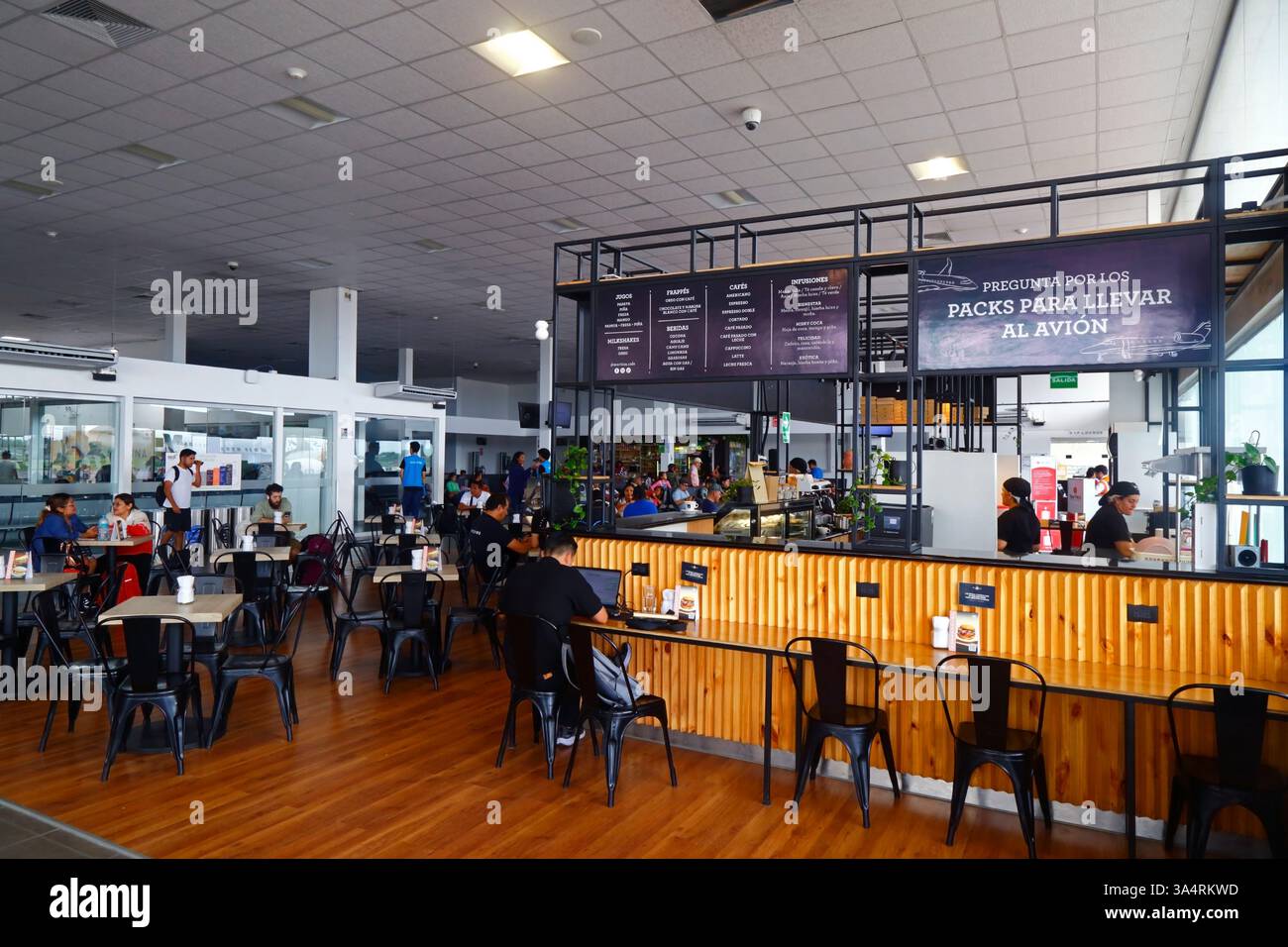 Passengers sitting at tables of Martina cafe inside departure lounge of ...