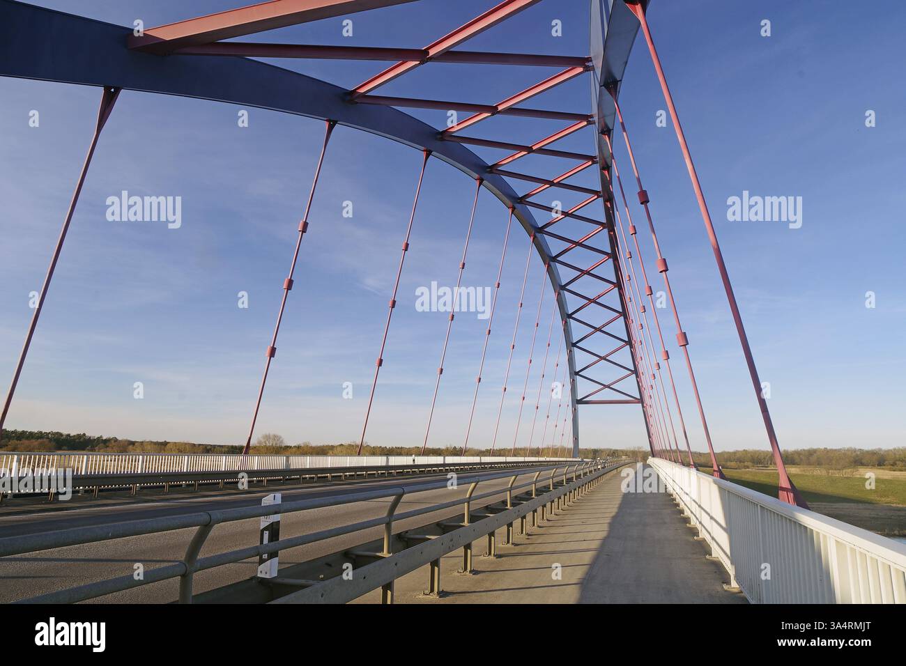 Modern bridge with blue and red struts under a clear sky, symbol of ...