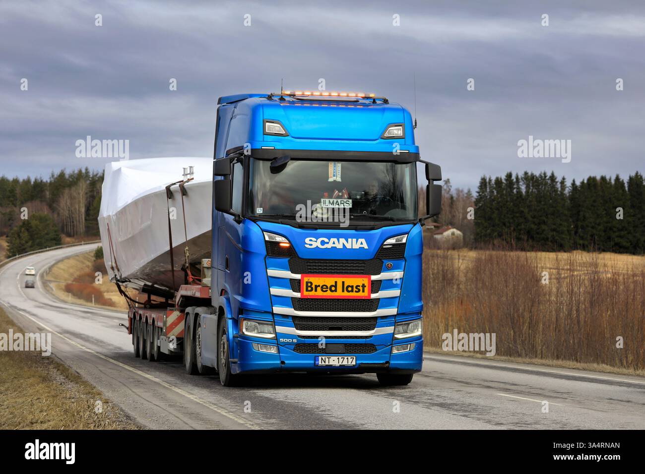 Blue Scania 500S gooseneck trailer transports large tarpaulin covered ...