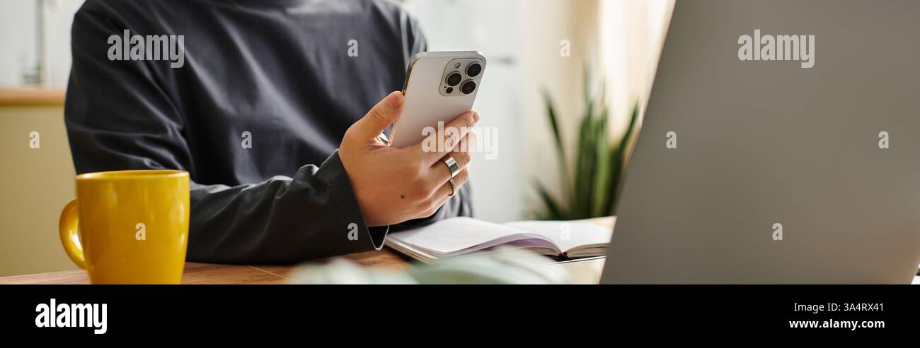 Focused student reviews notes online, using his laptop and smartphone ...