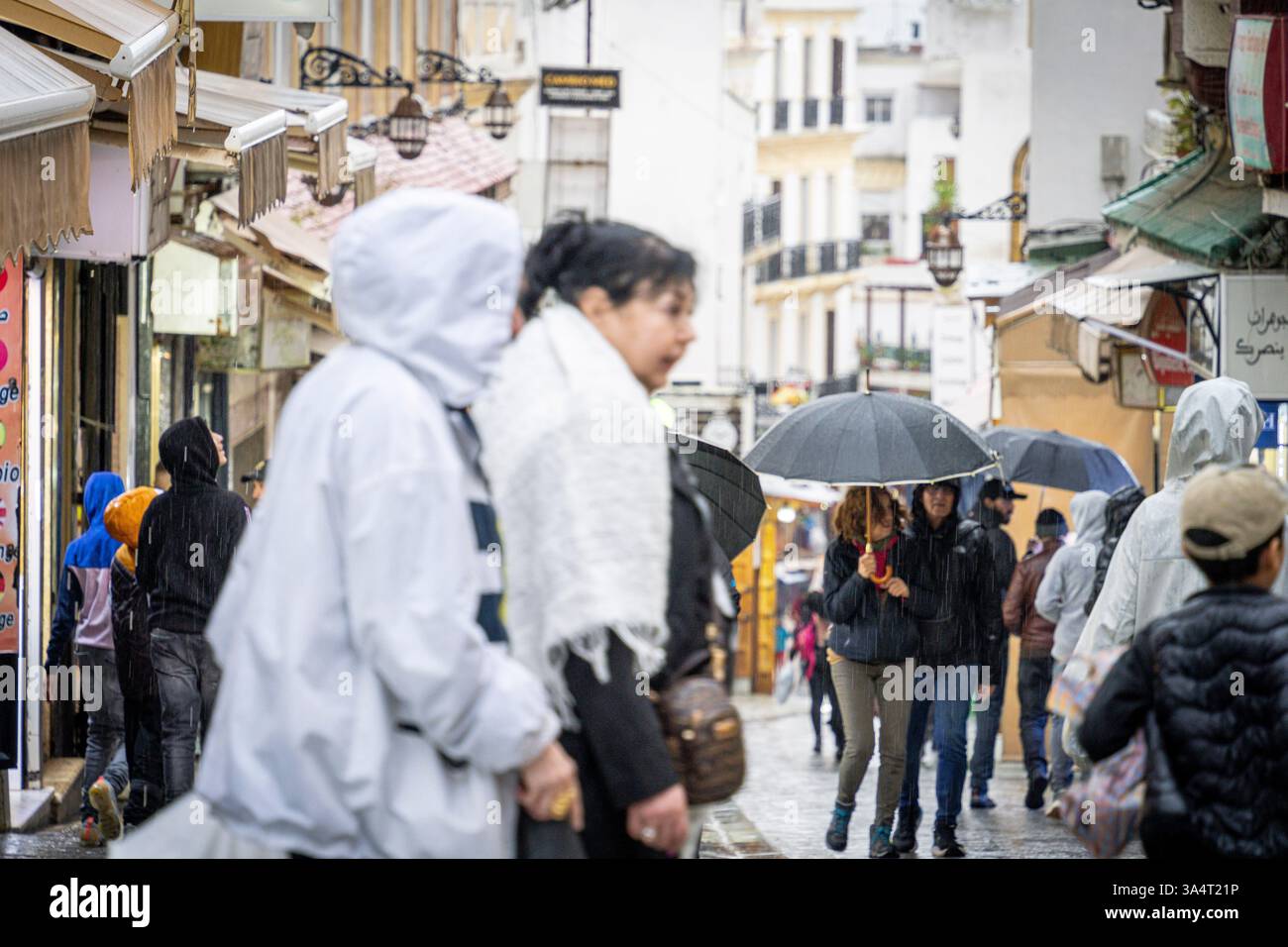 elderly tourist couple under an umbrella, Rainy day in the medina ...