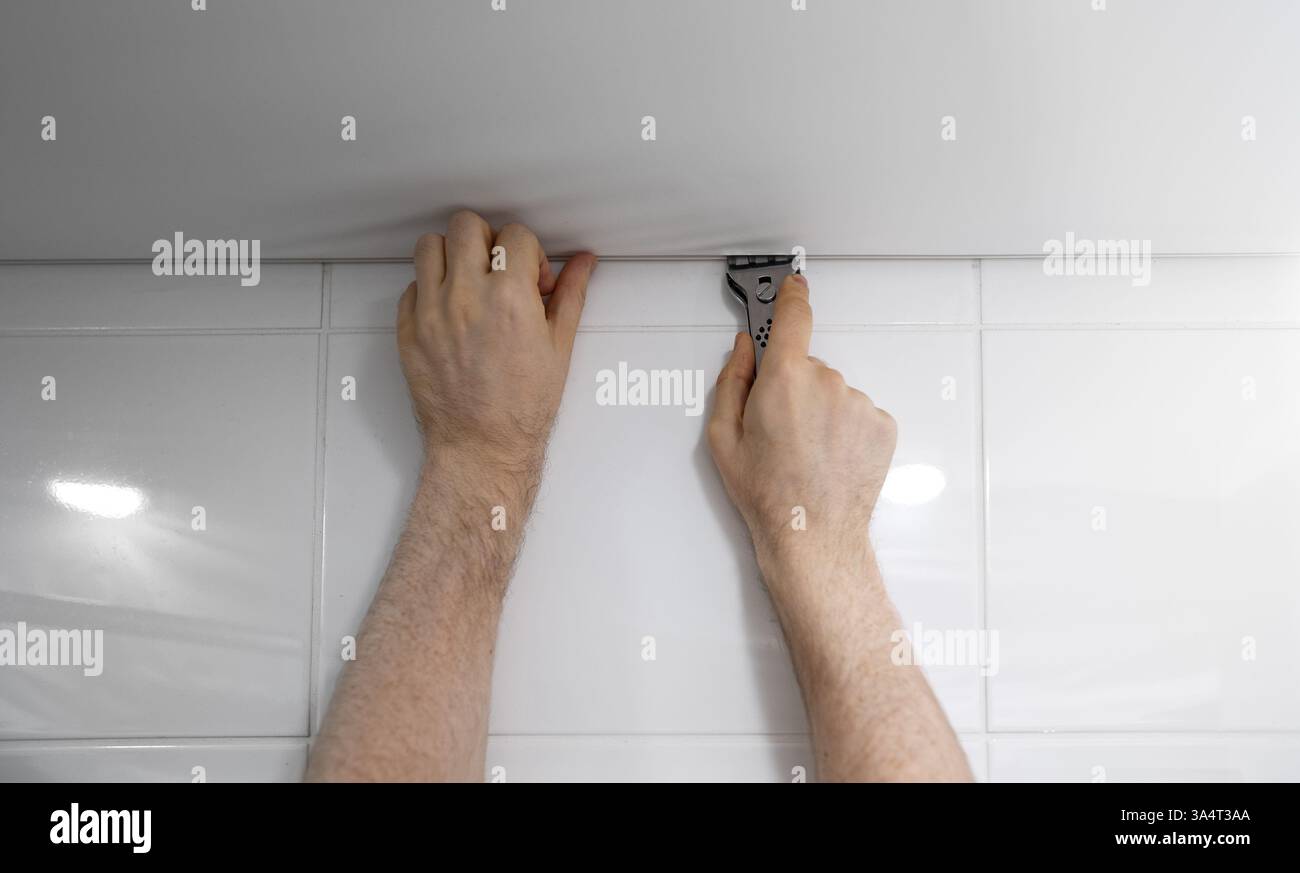 Installing a stretch ceiling in the bathroom Stock Photo - Alamy