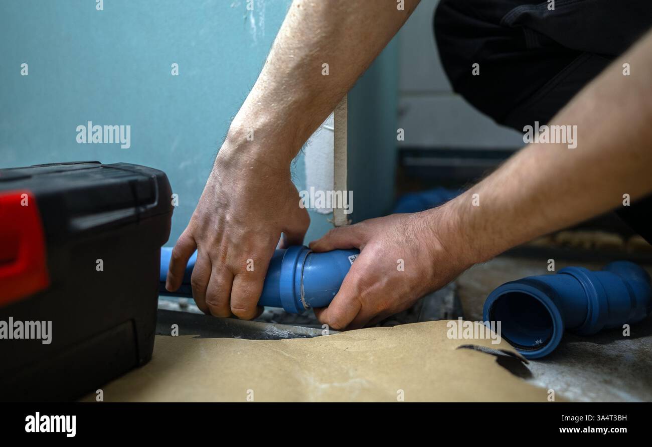 Man assembling plumbing pipes in the bathroom Stock Photo - Alamy