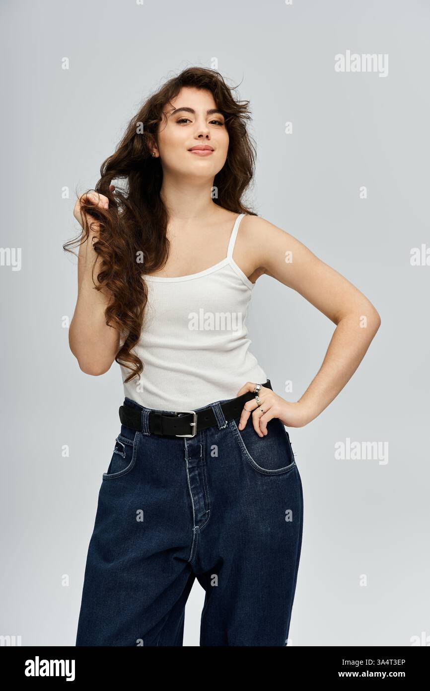 A young woman with flowing hair strikes a playful pose, displaying her ...
