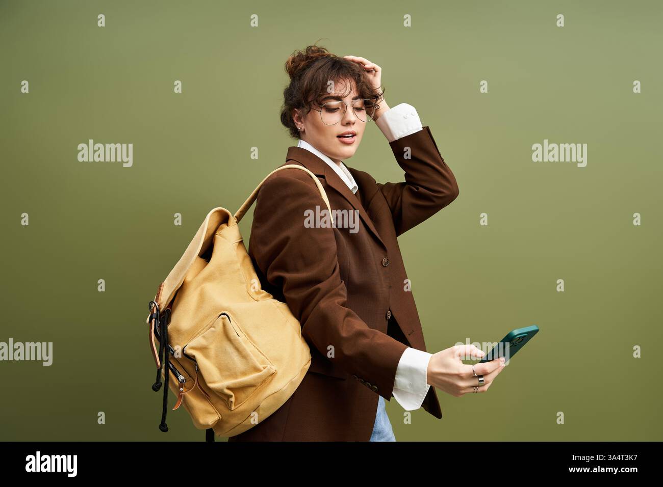 A stylish young woman poses playfully while looking at her phone Stock ...