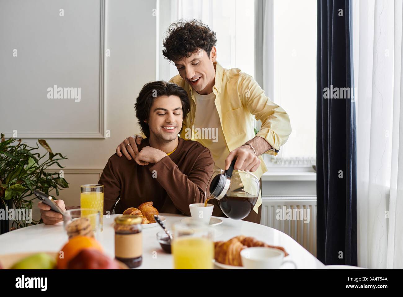 gay couple enjoying breakfast together in a contemporary living space ...
