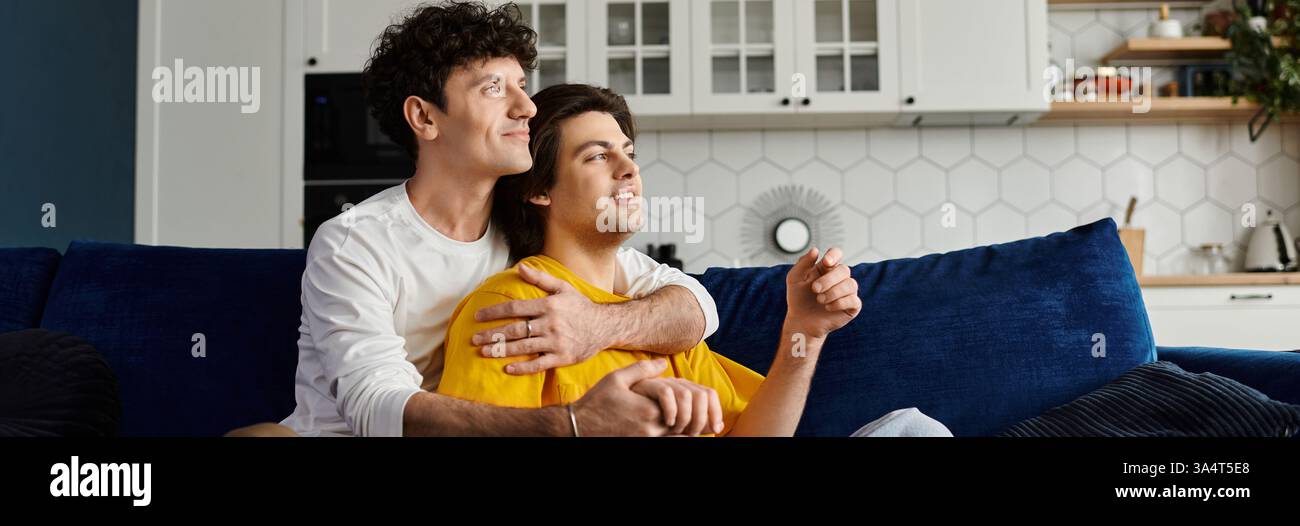 Two good-looking men embrace affectionately on a cozy couch while ...