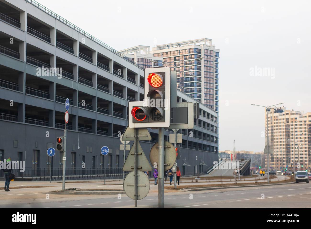 A detailed city scene showing a bright red traffic light at an ...