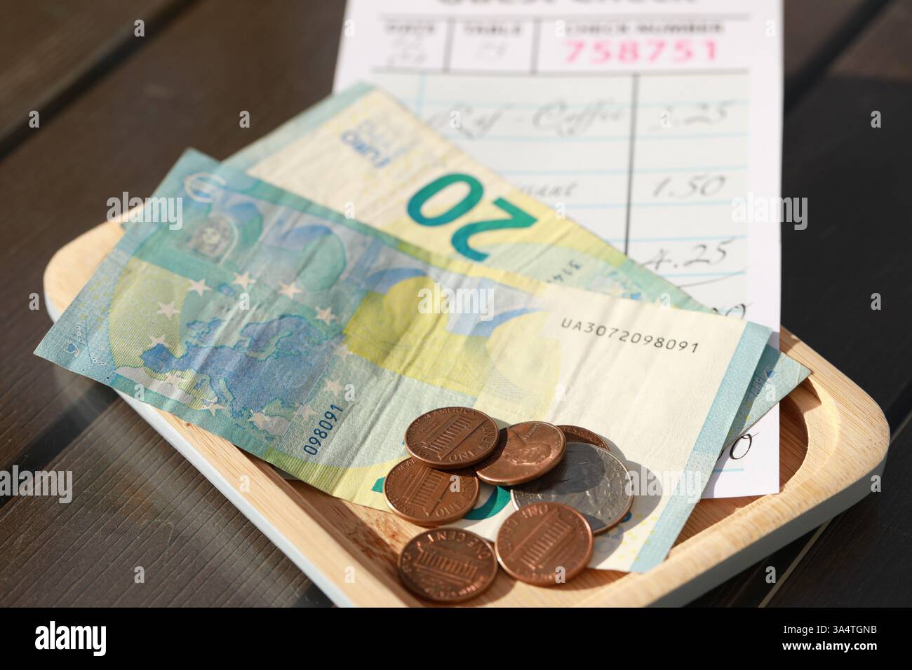Wooden plate with payment for order and receipt on table, closeup ...