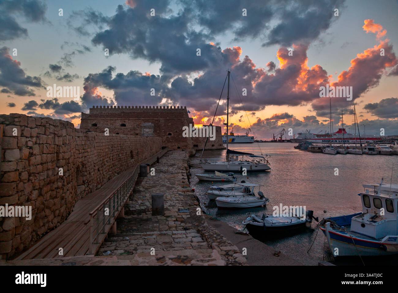 Sunrise over the old port of Heraklion, Crete, with majestic clouds and ...