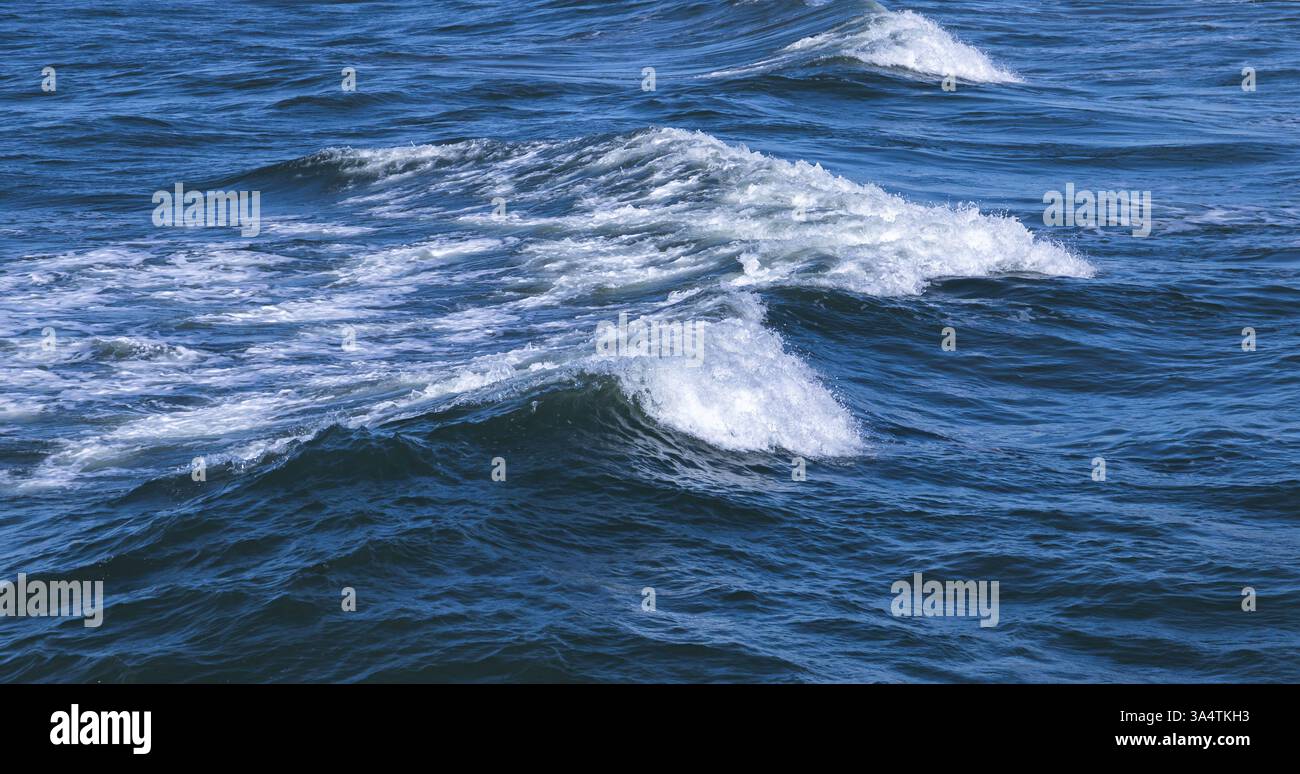 Ocean waves create beautiful textures of foam and movement under bright ...