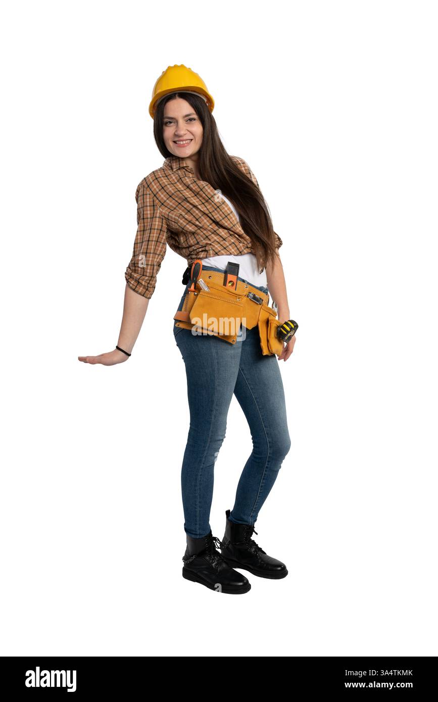 Smiling female construction worker in a plaid shirt and tool belt ...