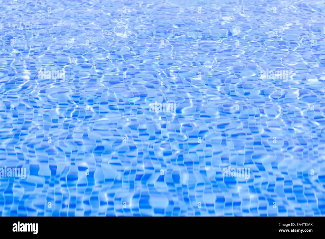 Bright blue surface of water with ripples reflecting light on a sunny ...