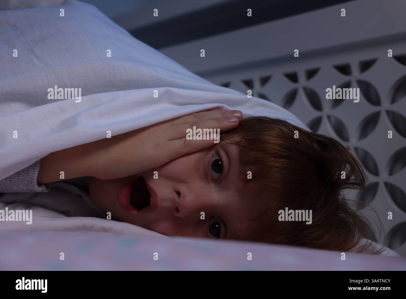 Afraid boy under blanket on bed at night Stock Photo - Alamy
