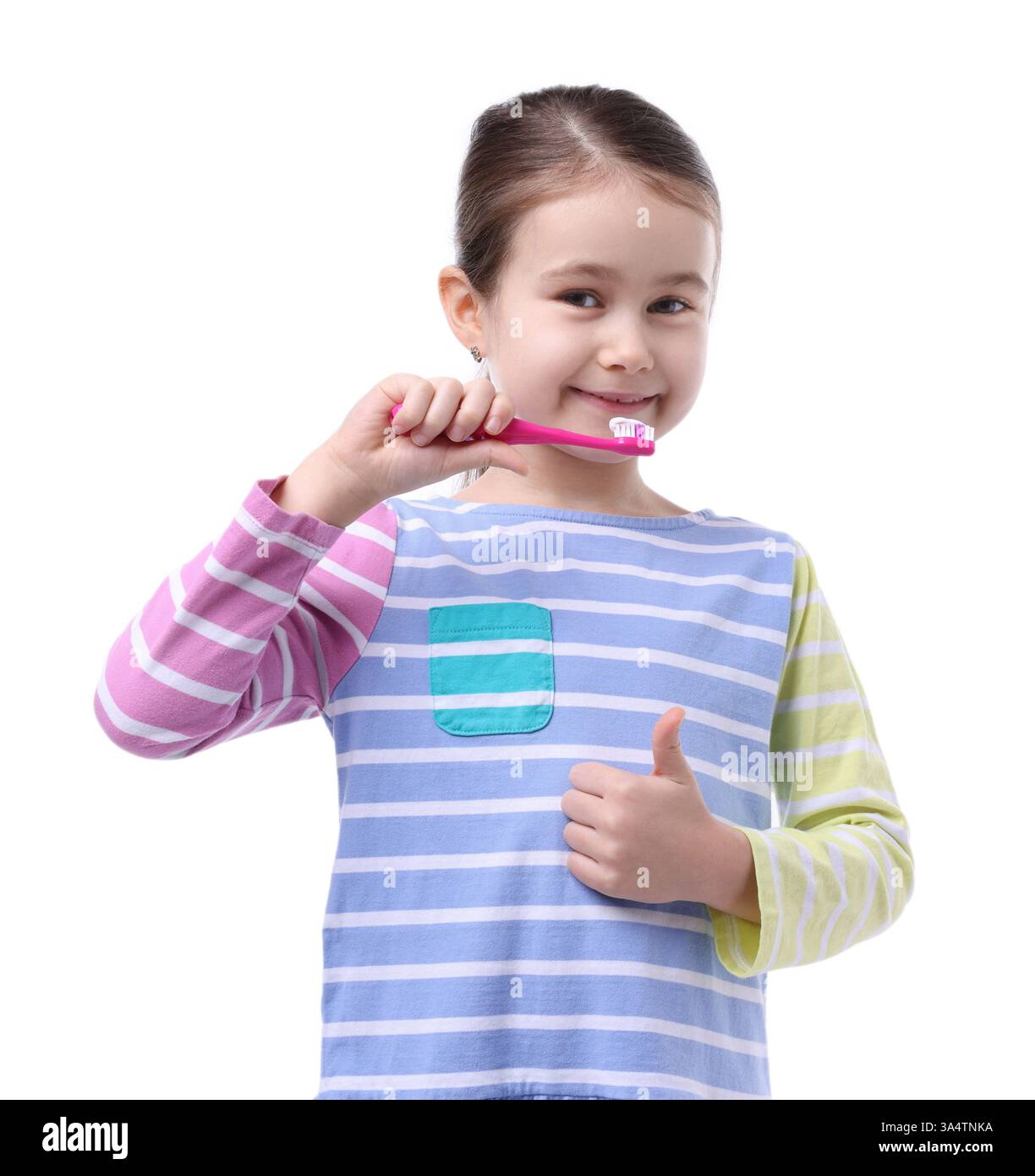 Cute girl brushing her teeth and showing thumbs up on white background ...