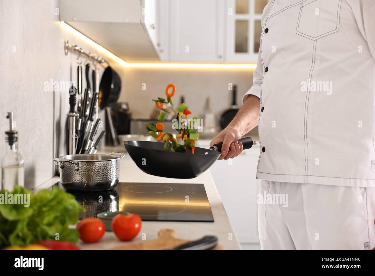 Professional chef mixing vegetables in wok at kitchen, closeup Stock ...