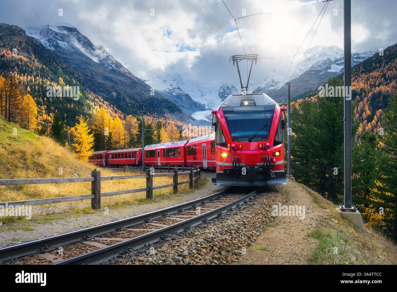 Red modern electric train traveling along a railway in mountains Stock ...