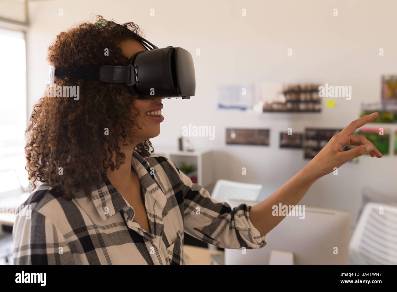 Woman using VR headset in office, interacting with virtual environment ...