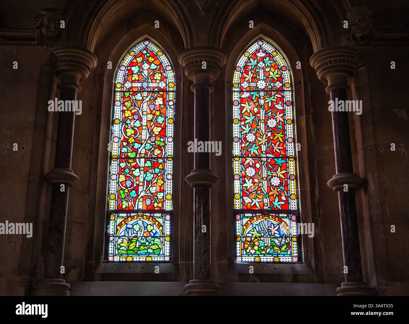 Two ornate Gothic arched stained glass windows featuring intricate ...