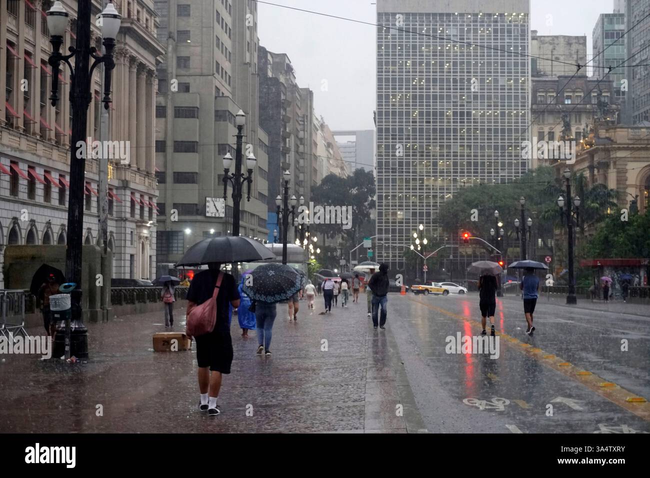 After a hot and muggy day, pedestrians face a storm in the city of São ...