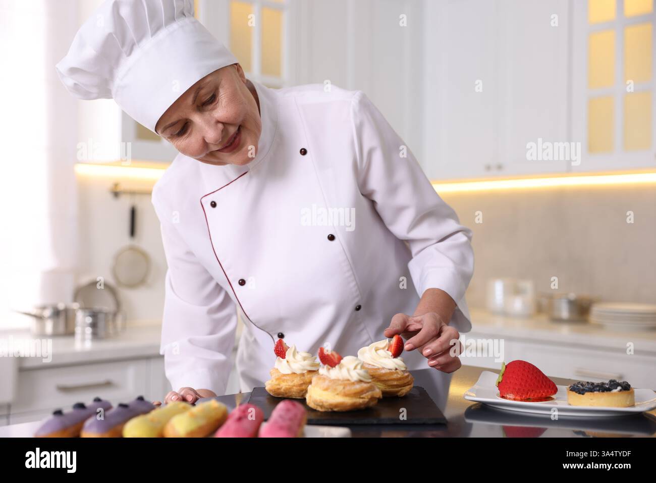 Professional pastry chef making desserts at table in kitchen Stock ...