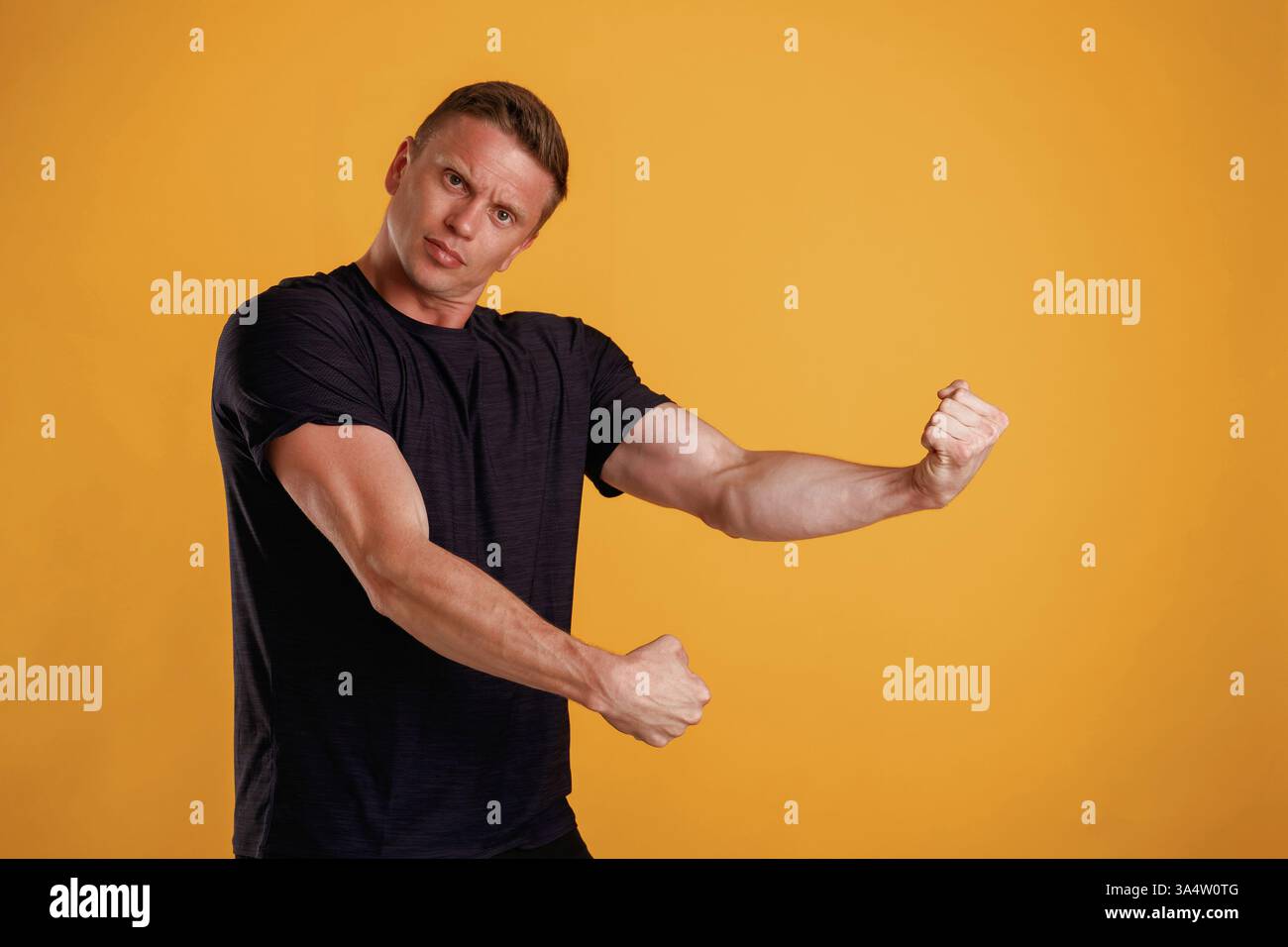 Strong arms, showing muscles. Man is against background in the studio ...