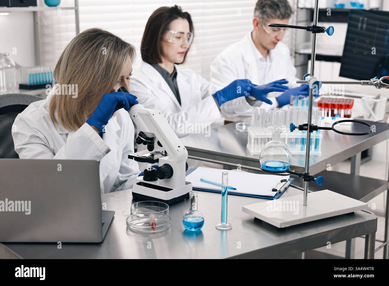 Scientists working with samples at table in laboratory Stock Photo - Alamy