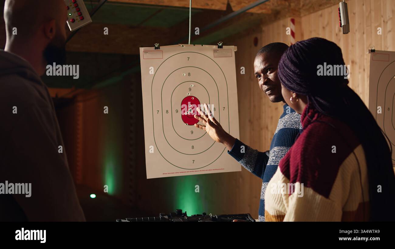 Shooting gallery instructor explaining bullseye scoring system to ...