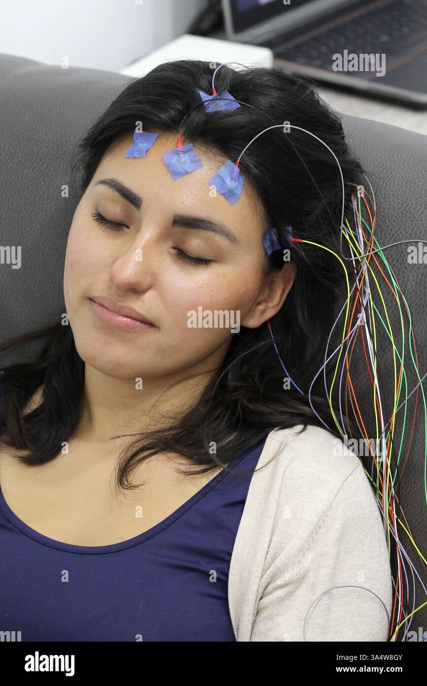 20-year-old Latin brunette woman undergoes EEG electroencephalogram neurological examination ...