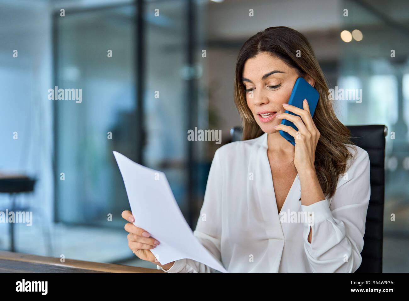 Busy middle aged professional business woman making call at work Stock ...