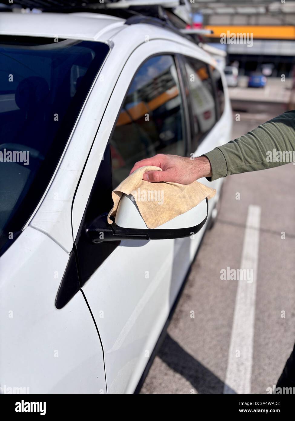 Man using a special cloth to wipe droplets off the window and mirrors ...
