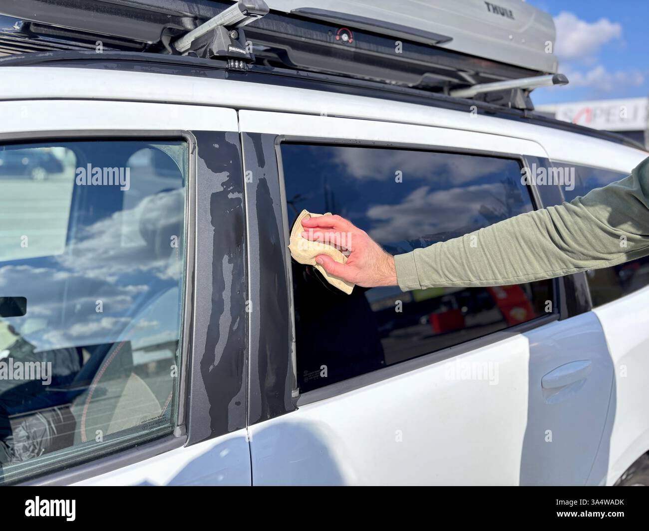 Man using a special cloth to wipe droplets off the window and mirrors ...