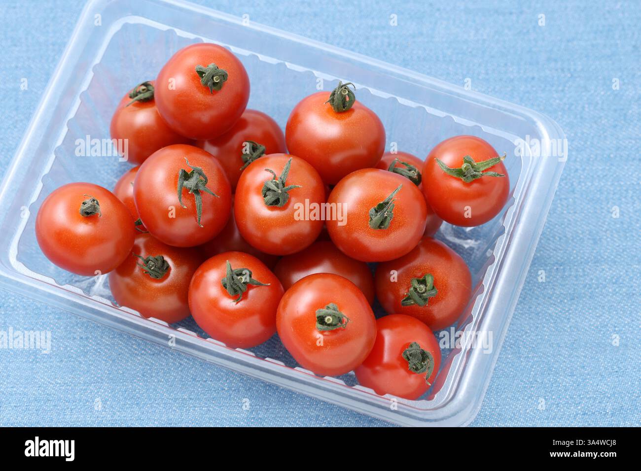 cherry tomatoes in a clear plastic container on table Stock Photo - Alamy