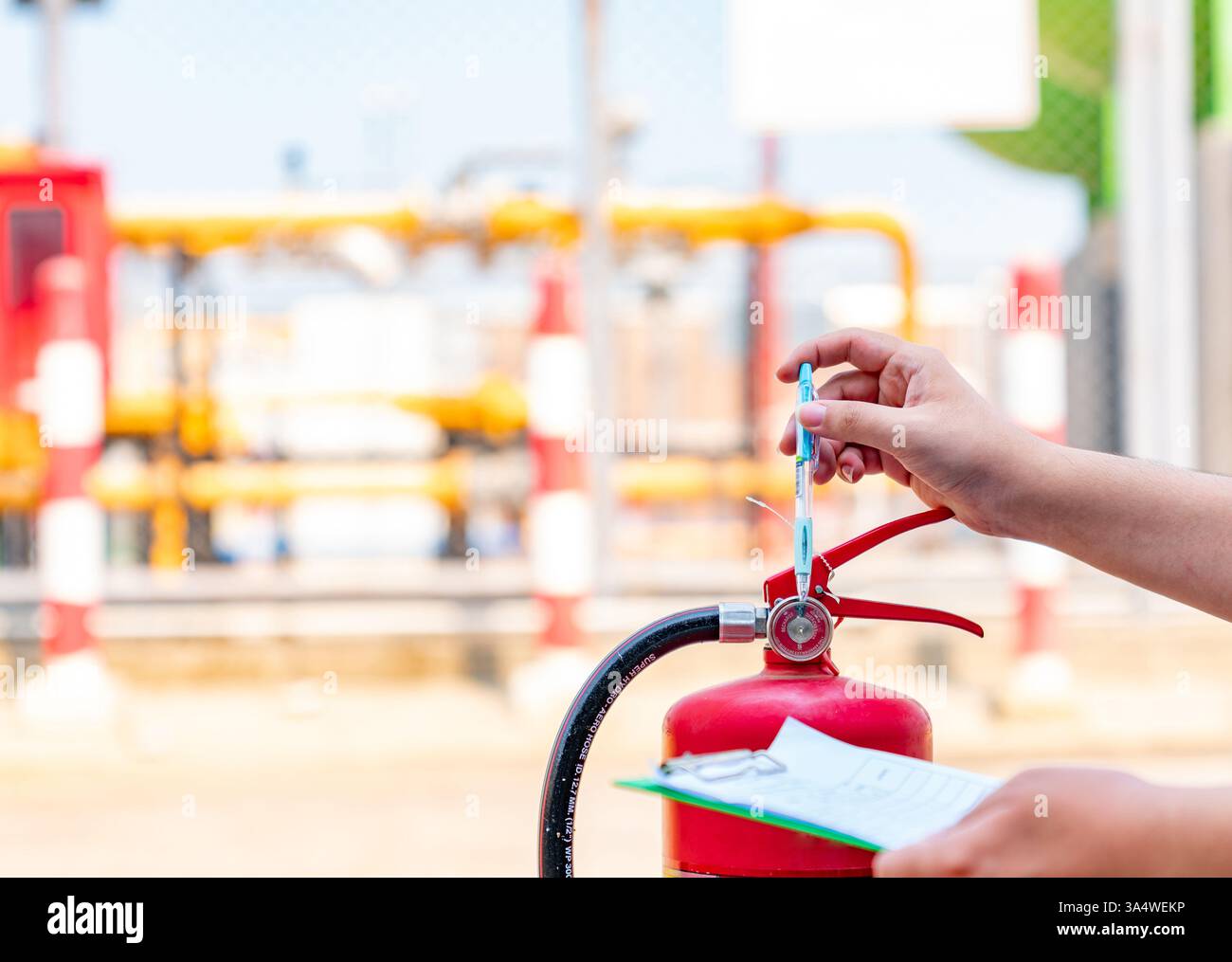 The safety office is checking gauge indicates of the fire extinguishers ...