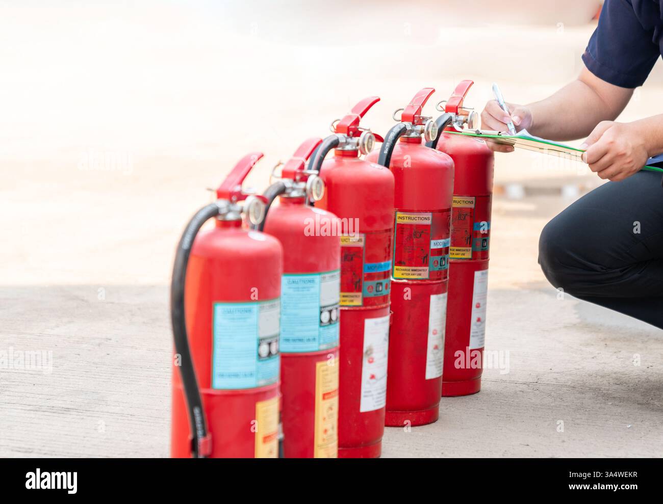 A safety officer inspector inspects fire extinguishers on blur ...