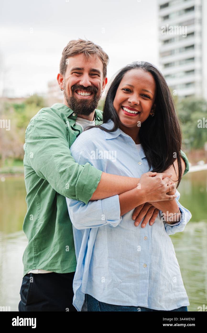 A cheerful couple joyfully embracing each other, both wearing bright ...