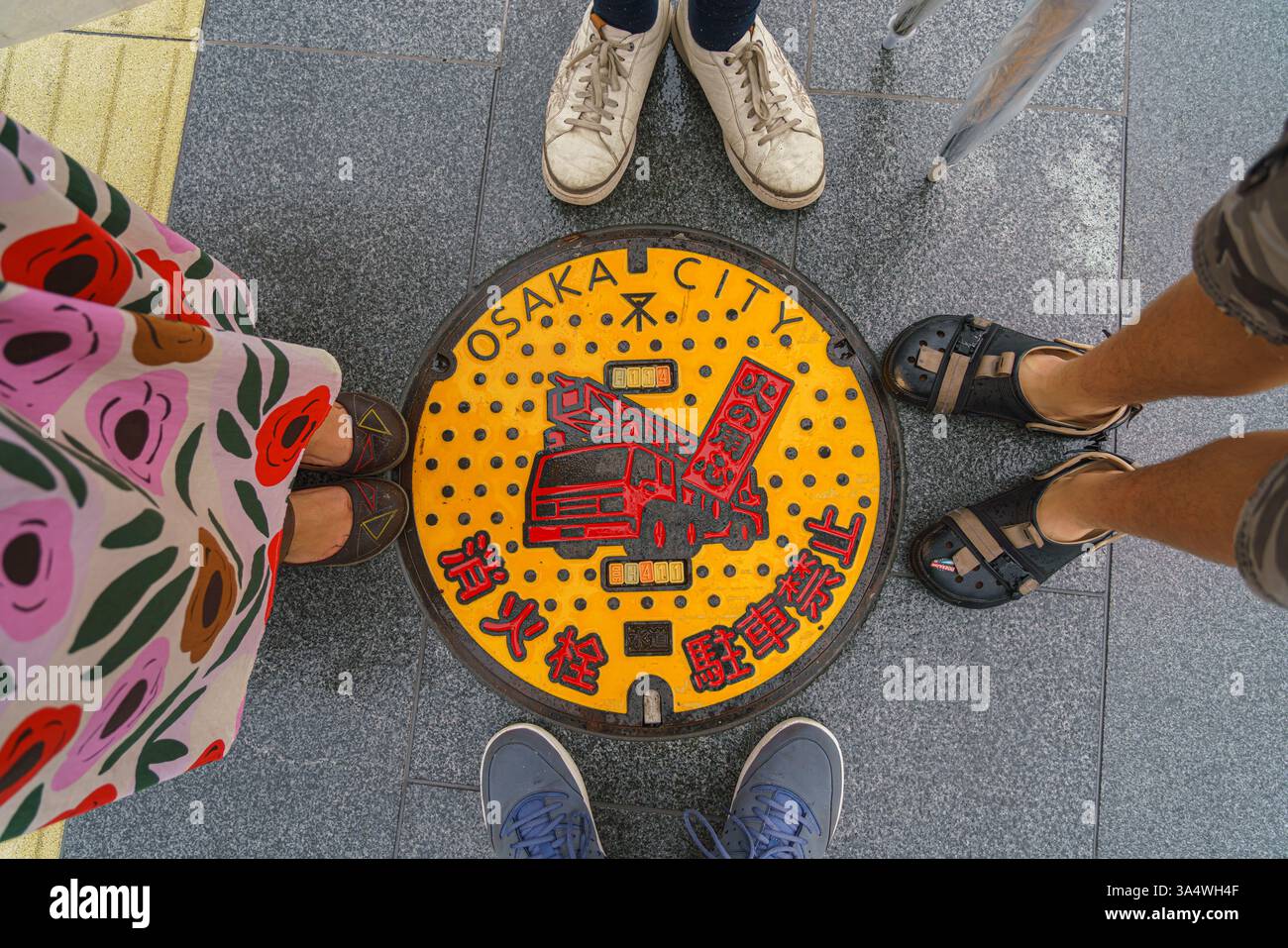 Osaka, Japan - Sep 22 2024, An overhead view of a manhole cover withred ...