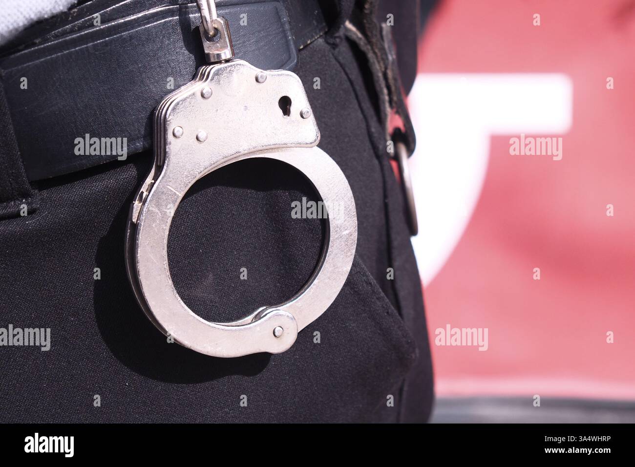 Police officer wearing handcuffs during a law enforcement activity ...