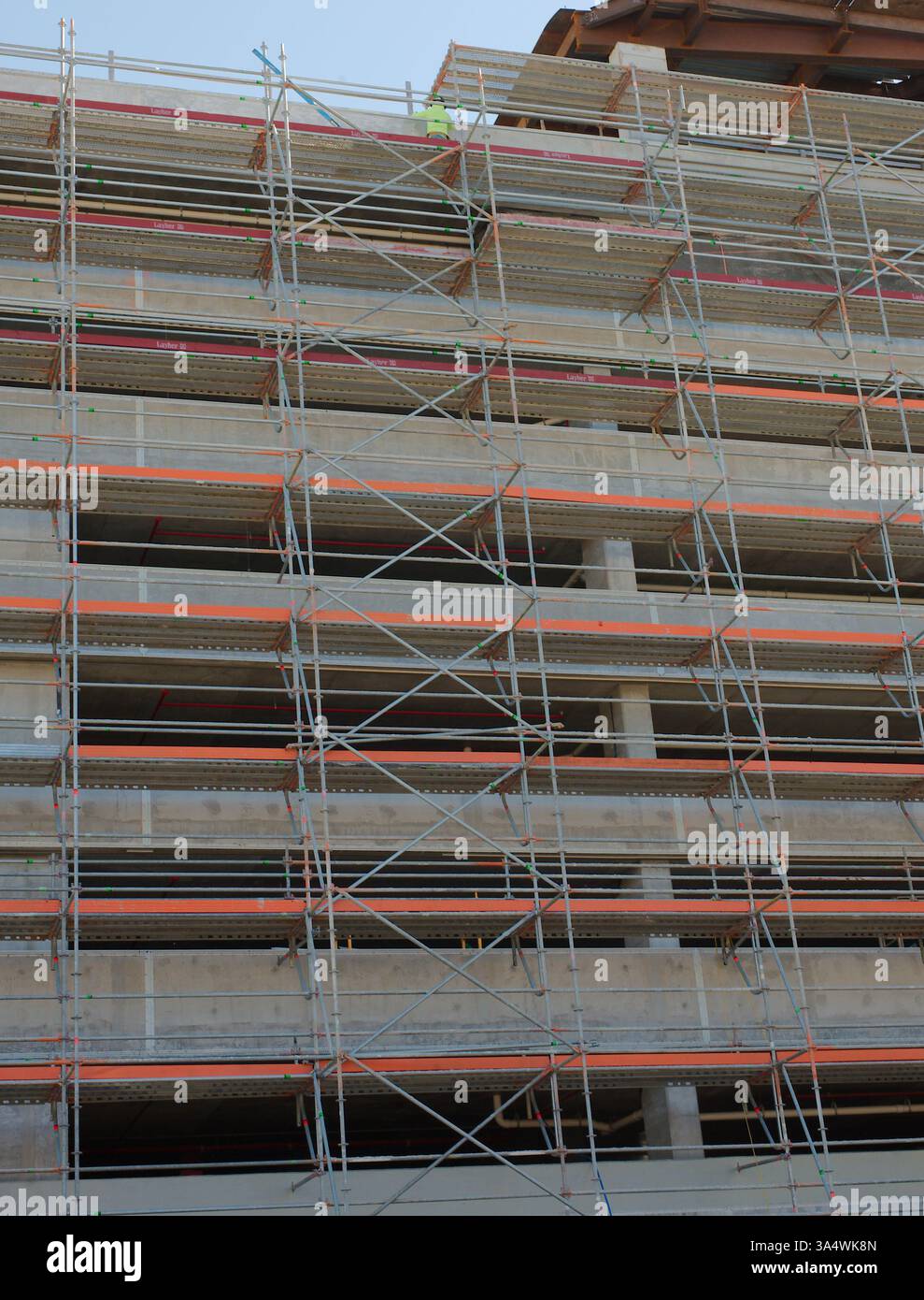 Building under construction enveloped in multi-level scaffolding ...