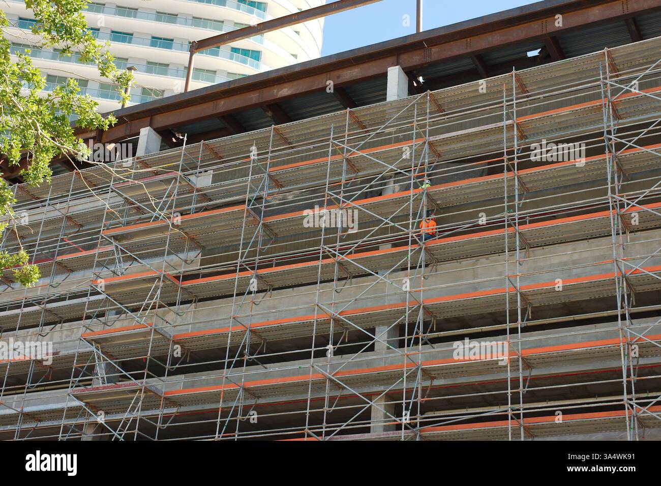 Building under construction enveloped in multi-level scaffolding ...