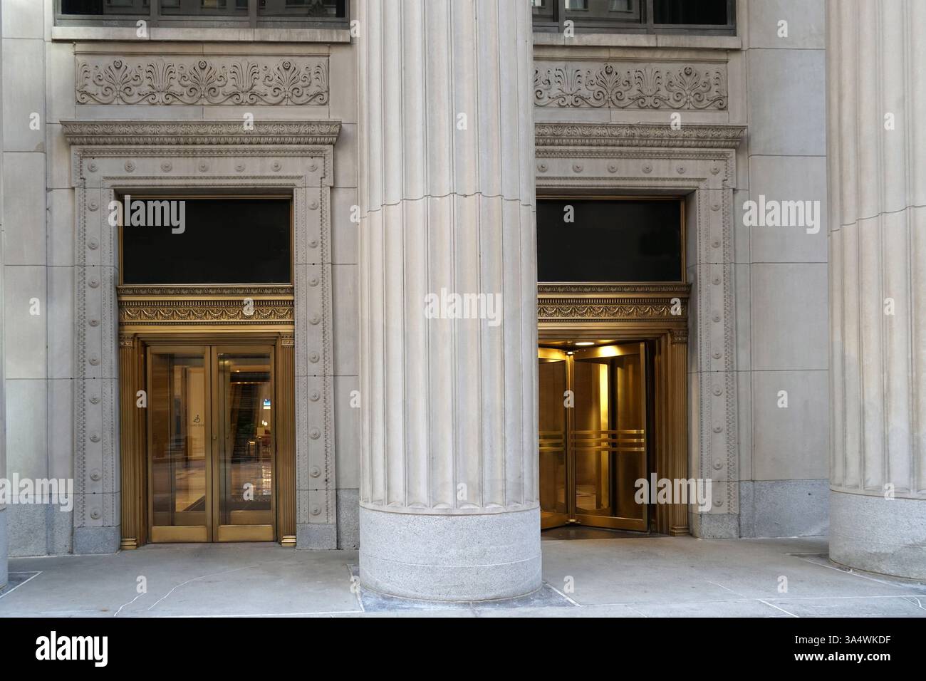 Entrance to office building with large stone columns and brass ...